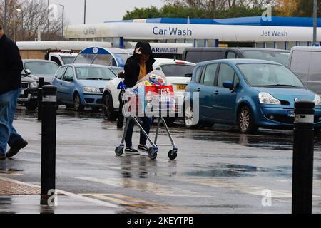 Ashford, Kent, UK. 15 Nov, 2022. UK Weather: Shoppers shield themselves ...