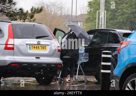 Ashford, Kent, UK. 15 Nov, 2022. UK Weather: Shoppers shield themselves ...