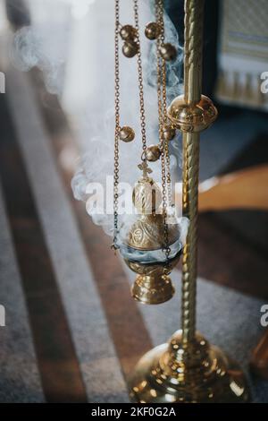 Golden chain censer with incense on burning charcoal. Close-up. During ...