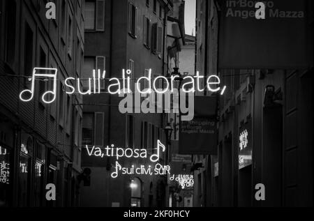 A street in Parma at night with neon signs hanging above Stock Photo ...