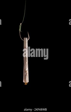 marijuana cigarette hanging from a hook drug addiction concept close-up ...
