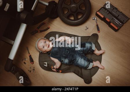 Mechanic baby boy repairing his baby stroller. Humor. Kid with tools ...