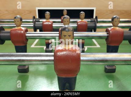One side of a vintage foosball or table football table with worn metal ...