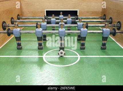 One side of a vintage foosball or table football table with worn metal ...