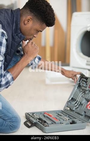 washing machine repairman choosing tool from toolbox Stock Photo - Alamy