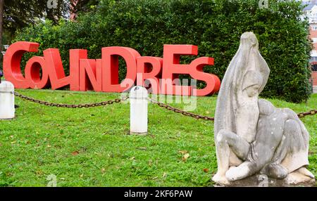 Colindres named in large red letters in a park with a stone sculpture ...