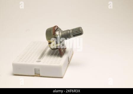 A variable resistor or potentiometer with code B10K sticks to a small ...