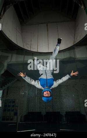 A woman flies in a wind tunnel. Free fall simulator Stock Photo - Alamy