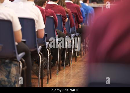 Group of primary school children seated on the floor during a school ...