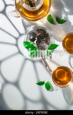 Gobo shadow, teatime with morning light, glass teapot and cups on a ...