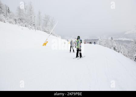 BUKOVEL, UKRAINE - DECEMBER 25: The skiers and snowborders are on slope ...
