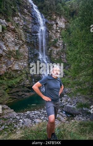 man under the Froda Waterfall in Sonogno, Switzerland Stock Photo - Alamy
