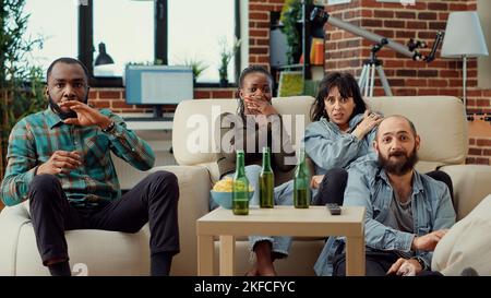 Diverse people getting scared watching horror thriller film, having ...