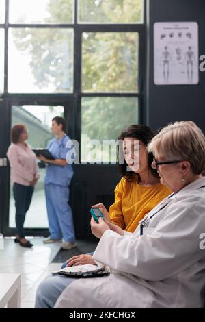 Medic and patient doing diabetic control during checkup visit ...