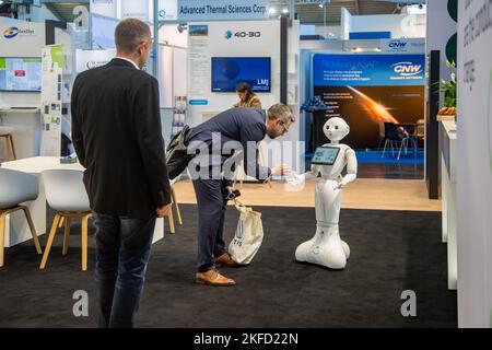 Mann spricht mit Roboter bei der Electronica / Semicon Europa Messe ...