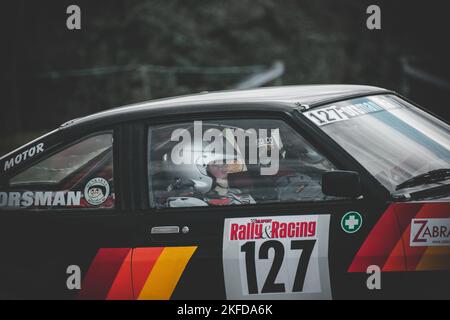 A vintage racing car surrounded by dust and smoke at the Zabra Rally in ...
