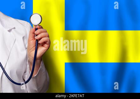 Swedish medical worker's hand with stethoscope on flag of Sweden ...