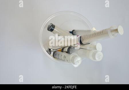 used syringes put in a clear white container Stock Photo - Alamy