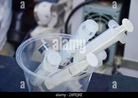 used syringes put in a clear white container Stock Photo - Alamy