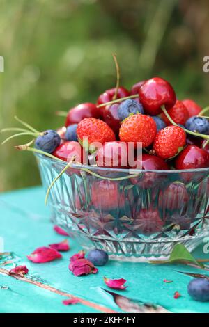 Glass bowl full of juicy organic berries. Summer still life with ...