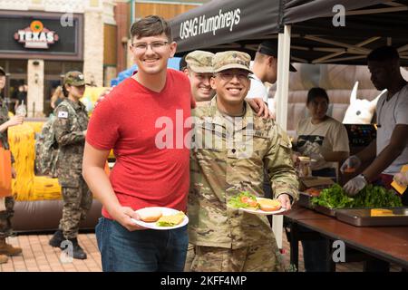 Members of the USAG Humphreys community enjoy free hamburgers cooked by ...