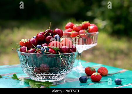 Glass bowl full of juicy organic berries. Summer still life with ...