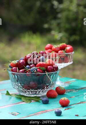 Glass bowl full of juicy organic berries. Summer still life with ...