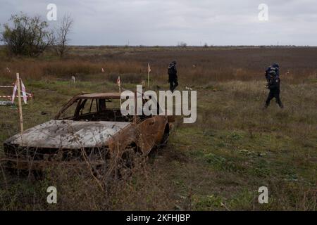 Several investigators seen conducting demining work at a field. Since ...