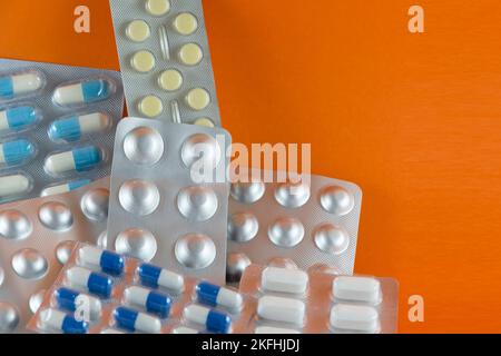 A bunch of different pills stacked on an orange background Stock Photo ...