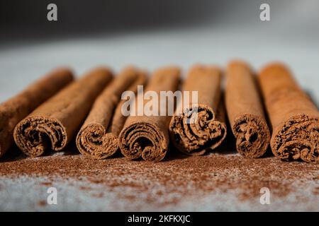 Ground Ceylon cinnamon sprinkled in front of real cinnamon sticks on a ...