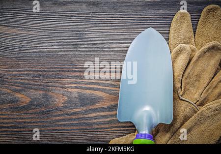 Hand spade pair of safety gloves on wooden board Stock Photo - Alamy