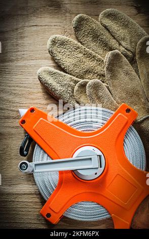 Leather protective gloves measuring tape on corrugated metal sheet ...