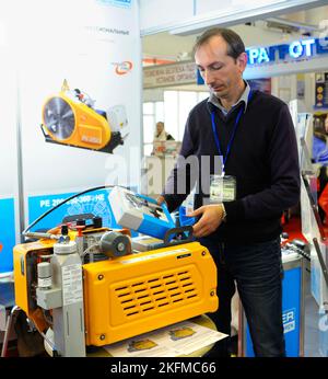 Manager showing diving equipment adjusting air compressor. Exhibition ...