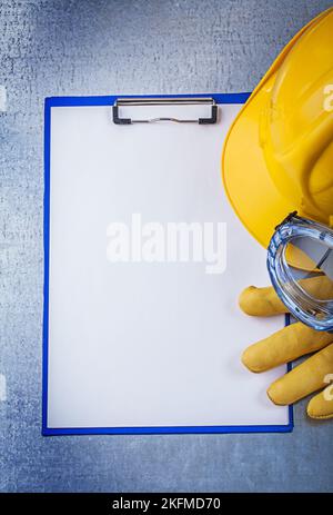 Plastic goggles protective gloves notepad building helmet on metallic ...