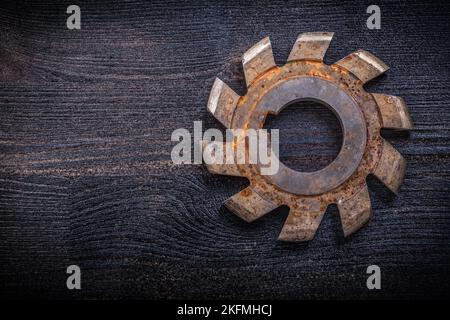 Vintage rotary cutter with cogs on wood board construction concept ...