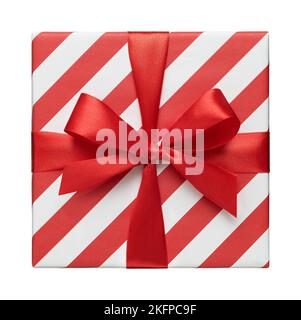A red Merry Christmas gift box with a gold ribbon viewed at an angle ...