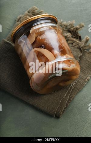 Jar with marinated mushrooms on green background Stock Photo - Alamy