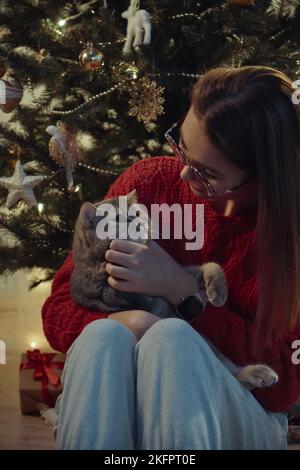 Young woman near the Christmas tree. Winter holidays Stock Photo - Alamy