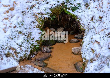 A natural spring of water flows from the hillside in the mountains of ...