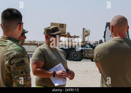 Spc. Andrew Welch of the 35th Infantry Division places crane hooks on ...
