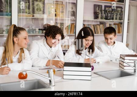 Chemistry lesson in labaratory in school. Pupils writing homework ...