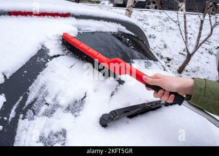 A driver removes ice from car after freezing rain (black ice) in Usti ...