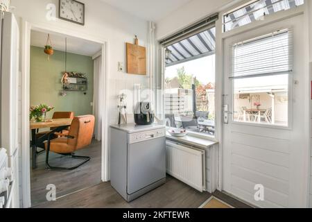 Light small home kitchen with wide window furnished with cupboards and ...