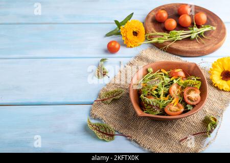 Vegetarian vegetables salad of tomatoes, marigold petals, microgreen ...