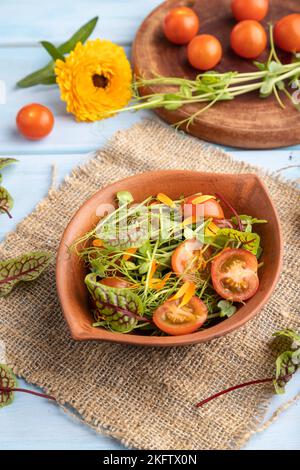 Vegetarian vegetables salad of tomatoes, marigold petals, microgreen ...