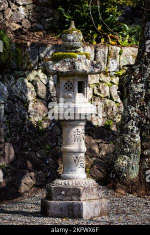 A close up of a traditional toro stone lantern within a Japanese garden ...