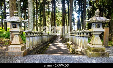 Entrance to traditional Japanese garden with stone path and tile roofed ...
