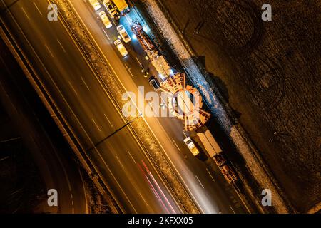 Convoy transporting heavy equipment, aerial night landscape of TBM ...