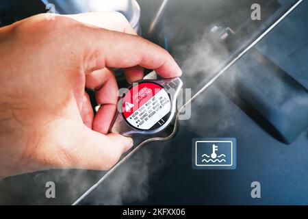 The mechanic hand was holding onto the car hot radiator cap with the ...