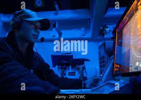 U.S. Navy Operations Specialist 1st Class Gavin Hawthorne points at a ...